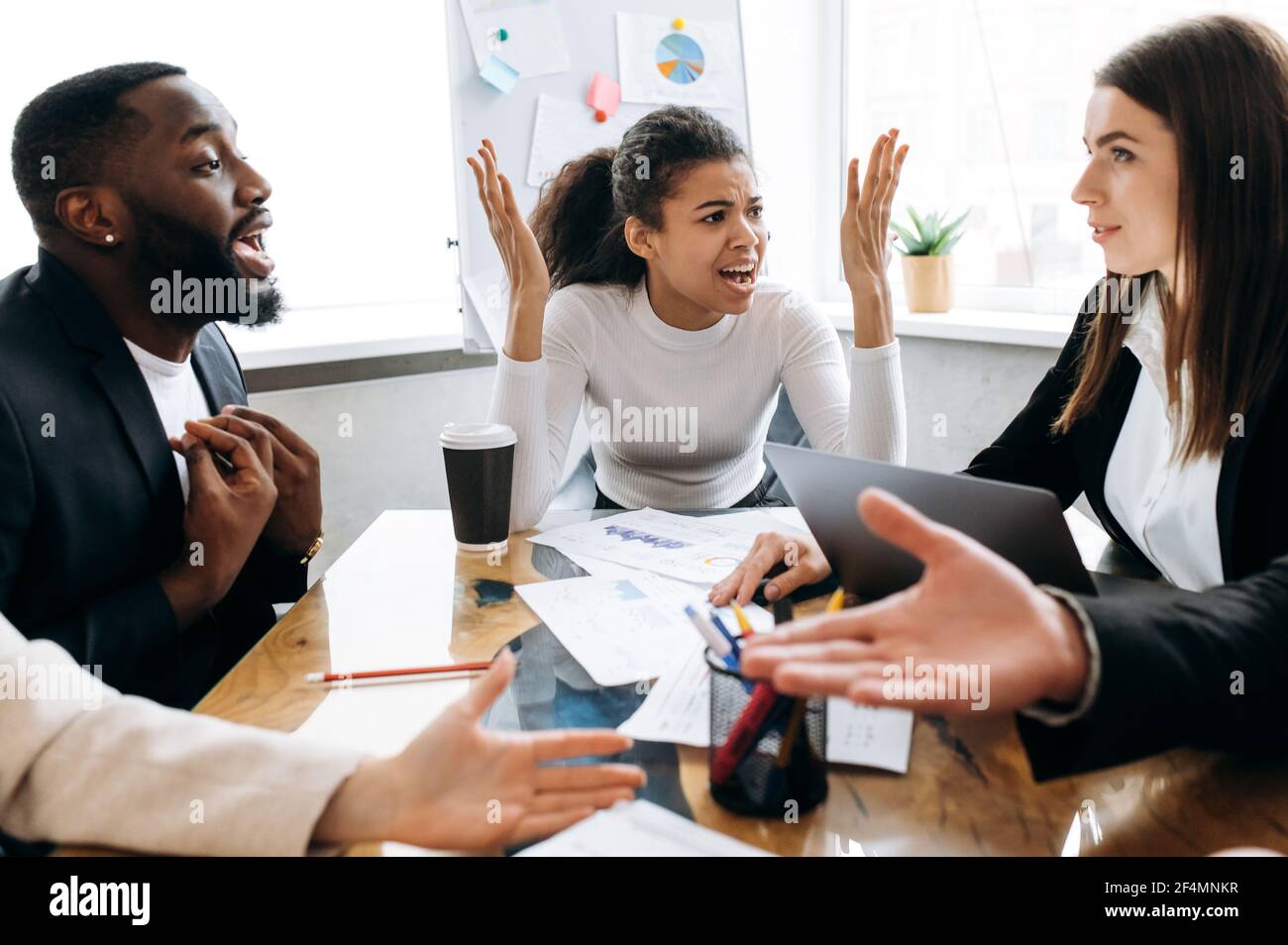 Emotional young adult people having a conflict on business meeting ...