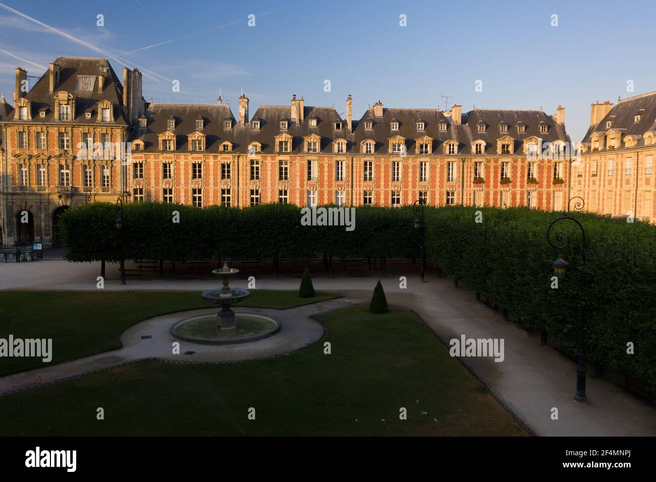 Lush green park in front of historical brick building of Place des ...