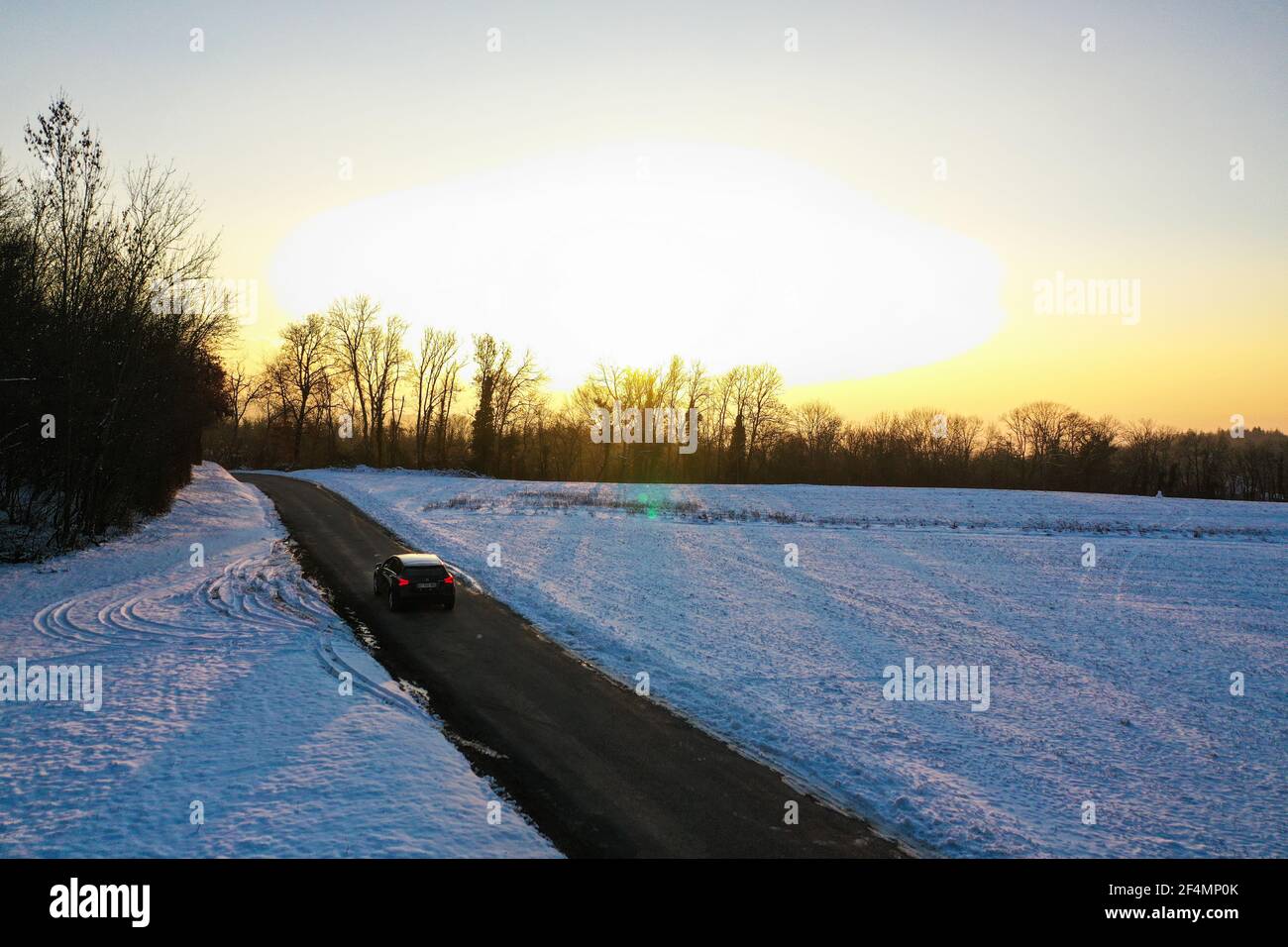 Black Mercedes Virtuo car driving into the sunset on a winter evening ...