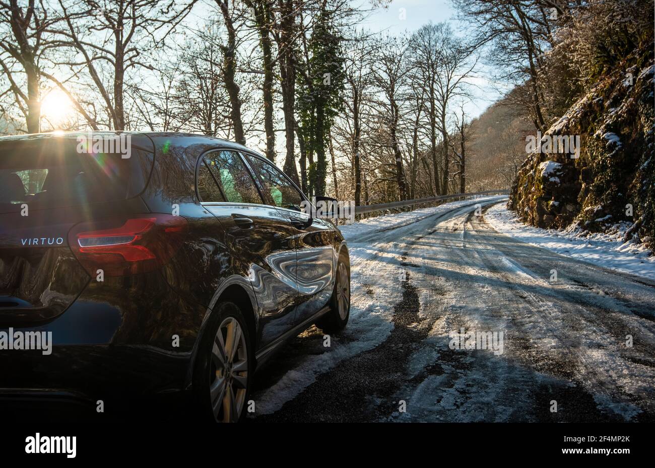 Black Mercedes Virtuo car on mountain road in the winter. Close up back ...