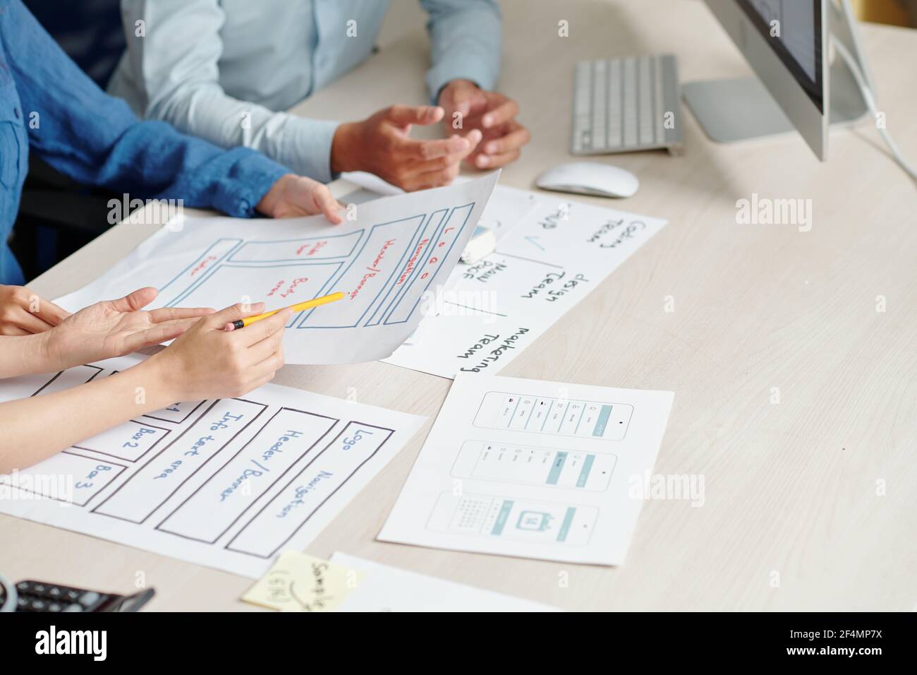 Manager showing layout of application interface to colleagues Stock ...