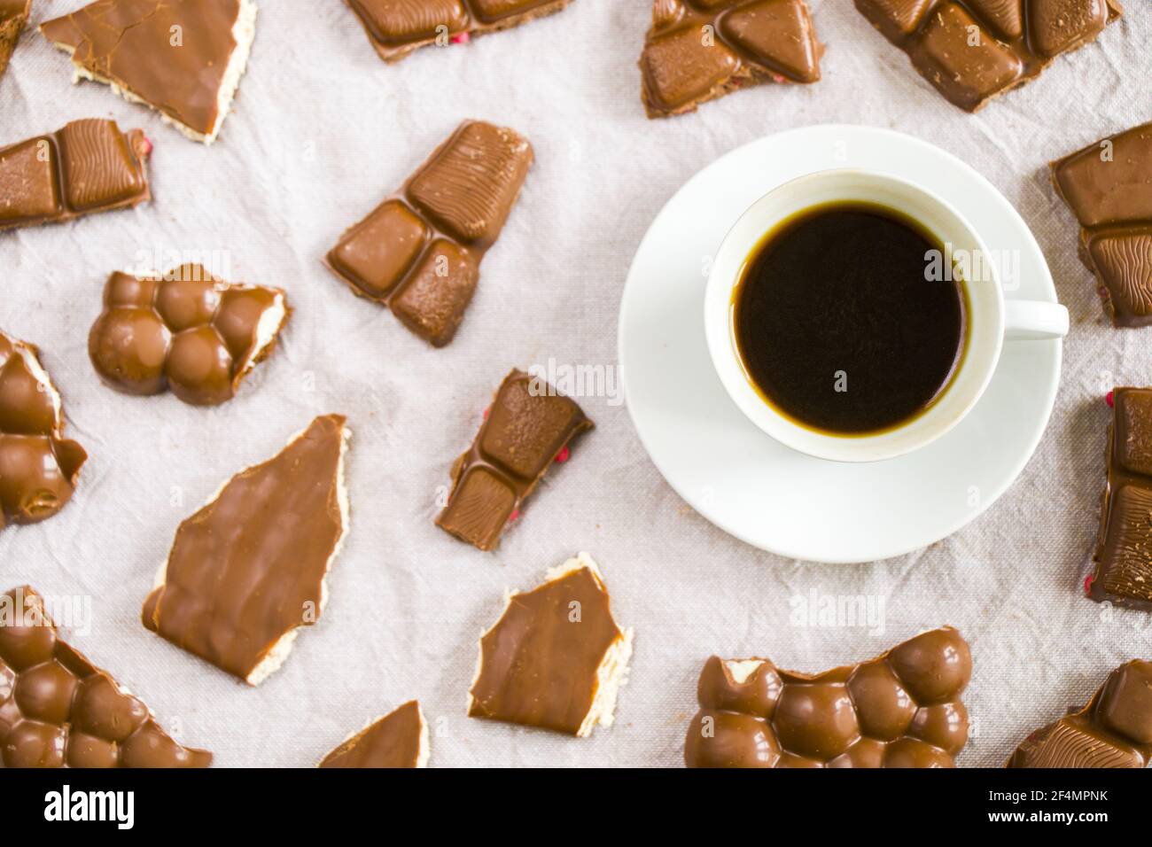 Cup of black espresso coffee and chocolate bars on the white cloth ...
