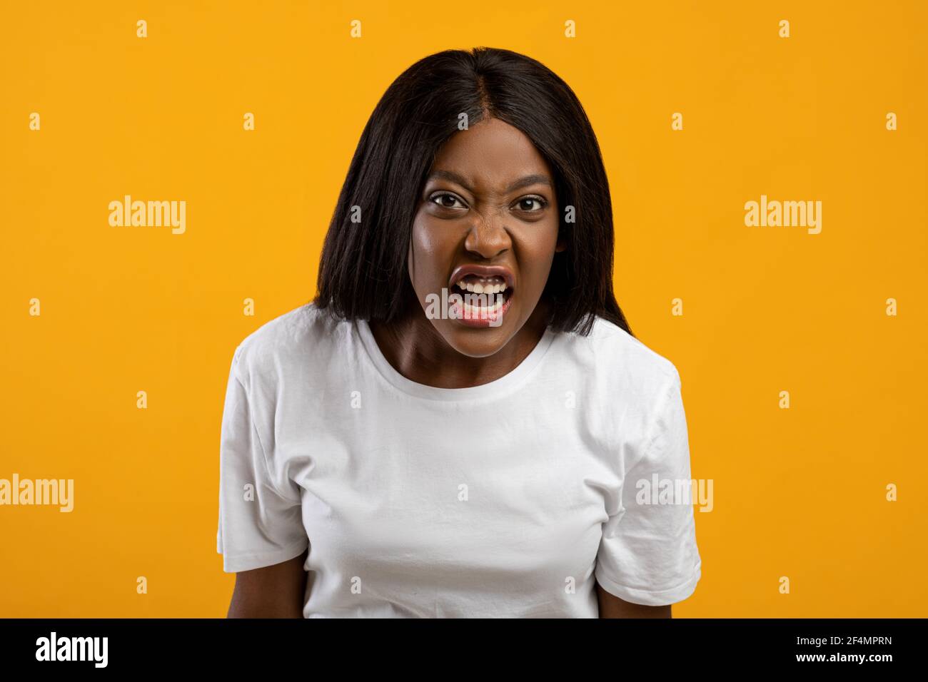 Angry black lady yelling at camera, yellow background Stock Photo - Alamy