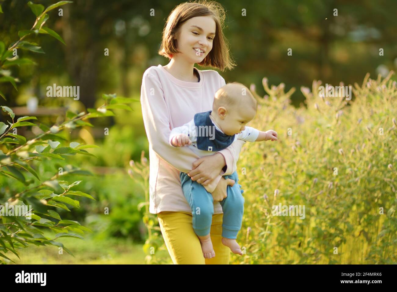 Cute big sister cuddling with her baby brother. Adorable teenage girl ...