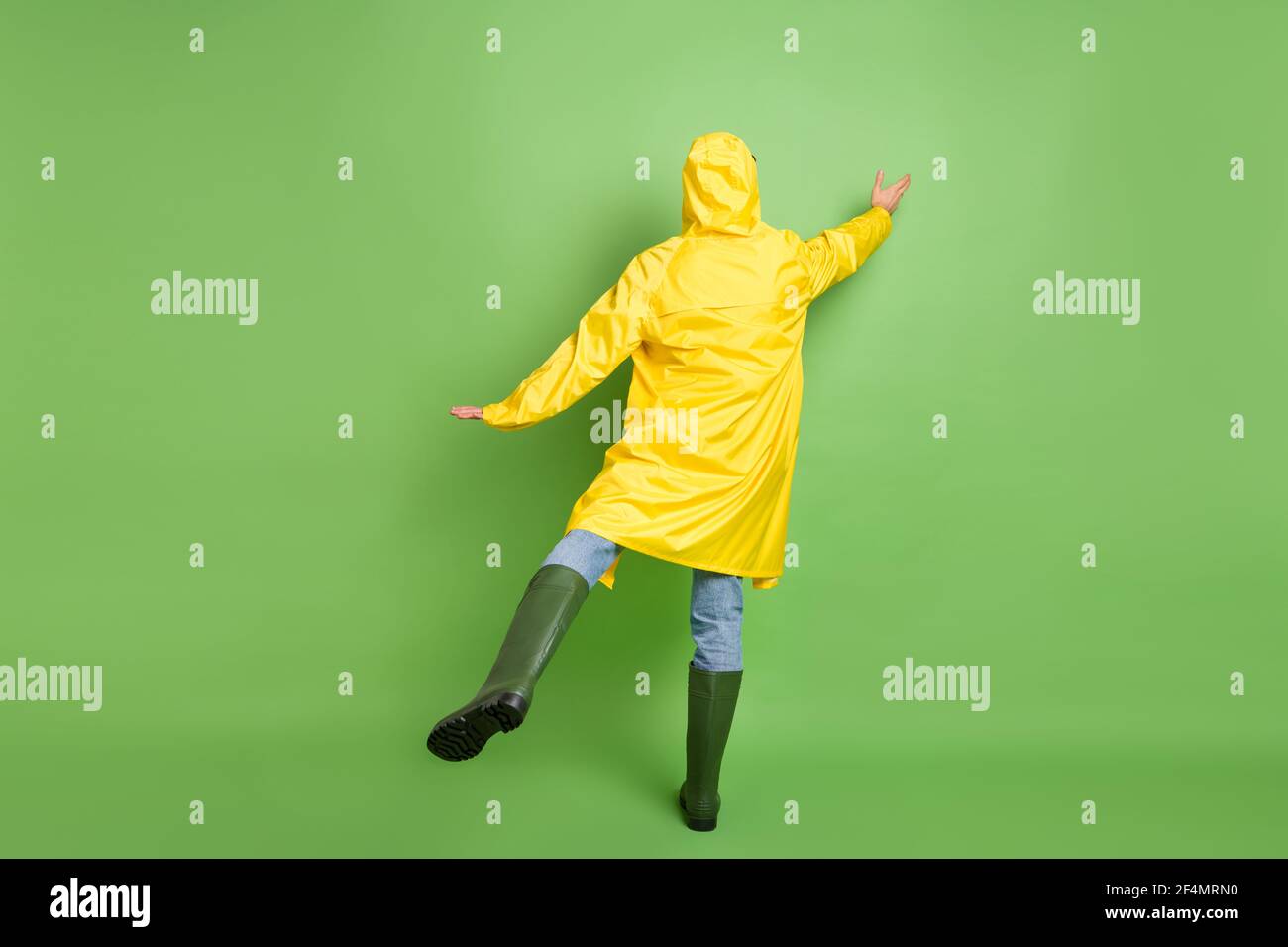 Back rear view photo of young man rainy weather wear raincoat try to ...