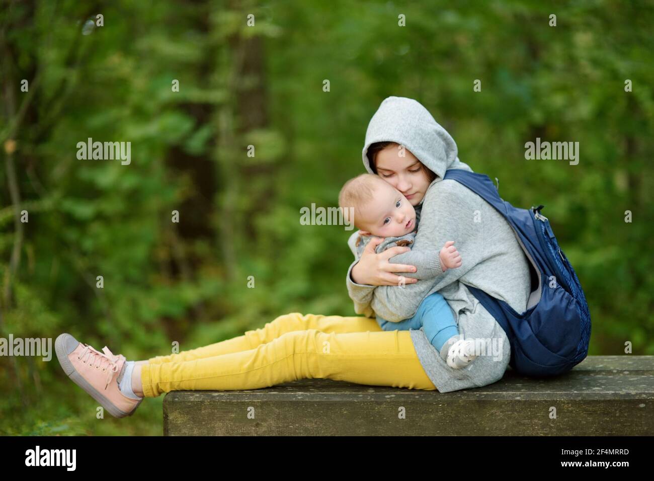 Cute big sister cuddling with her baby brother. Adorable teenage girl ...