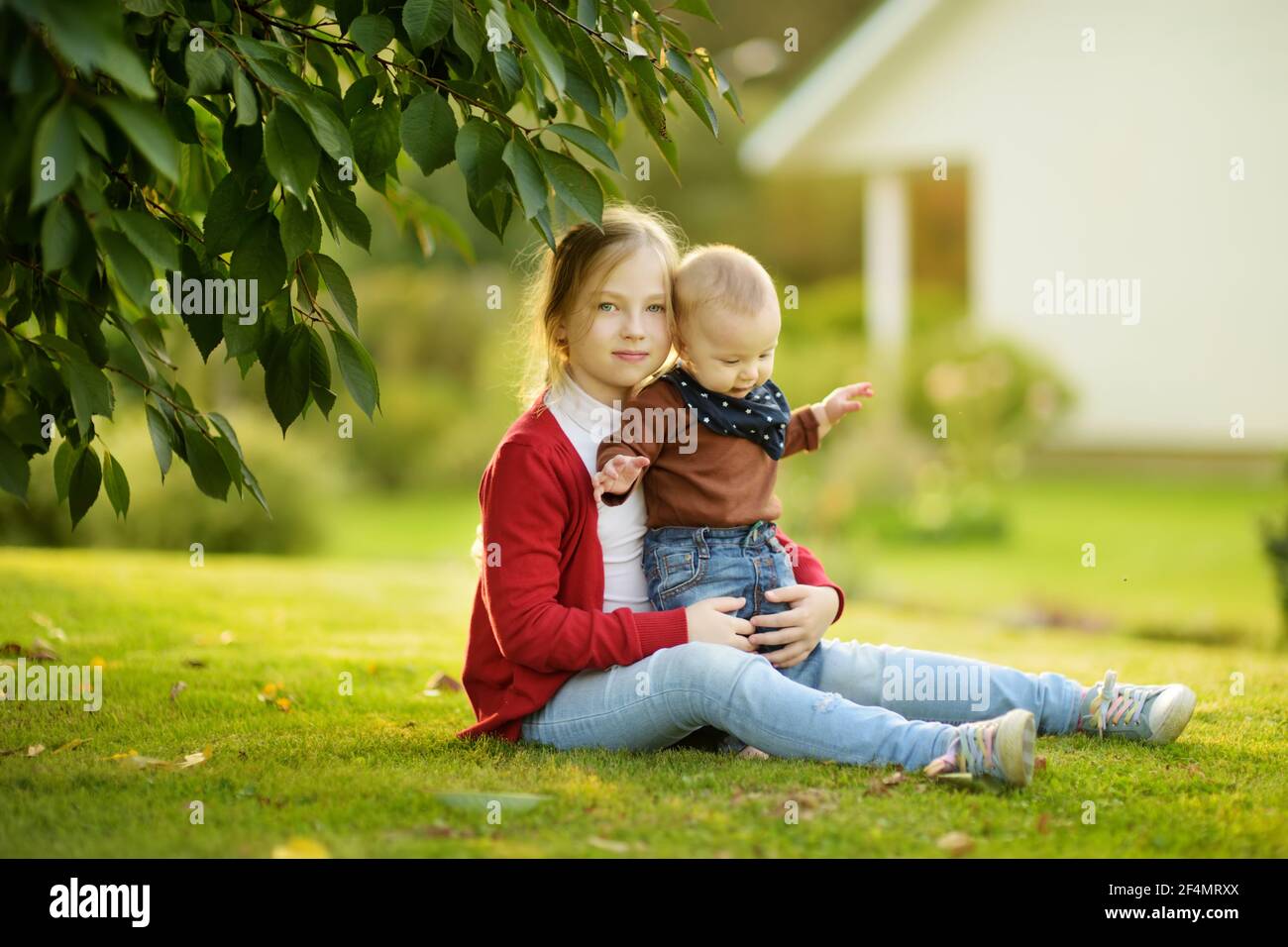 Cute big sister cuddling with her baby brother. Adorable teenage girl ...