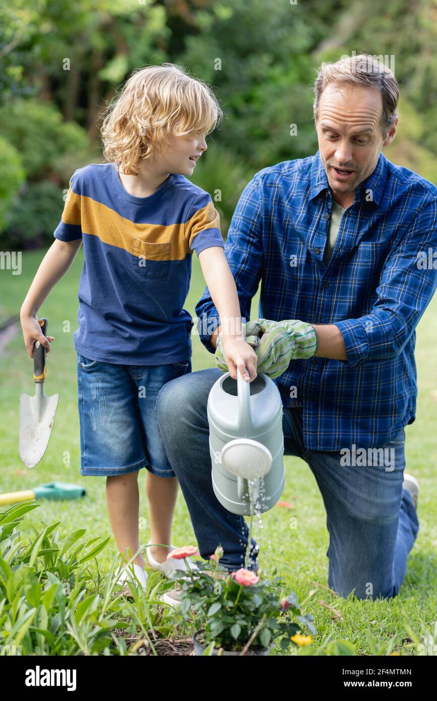 Father son watering plant in hi-res stock photography and images - Alamy