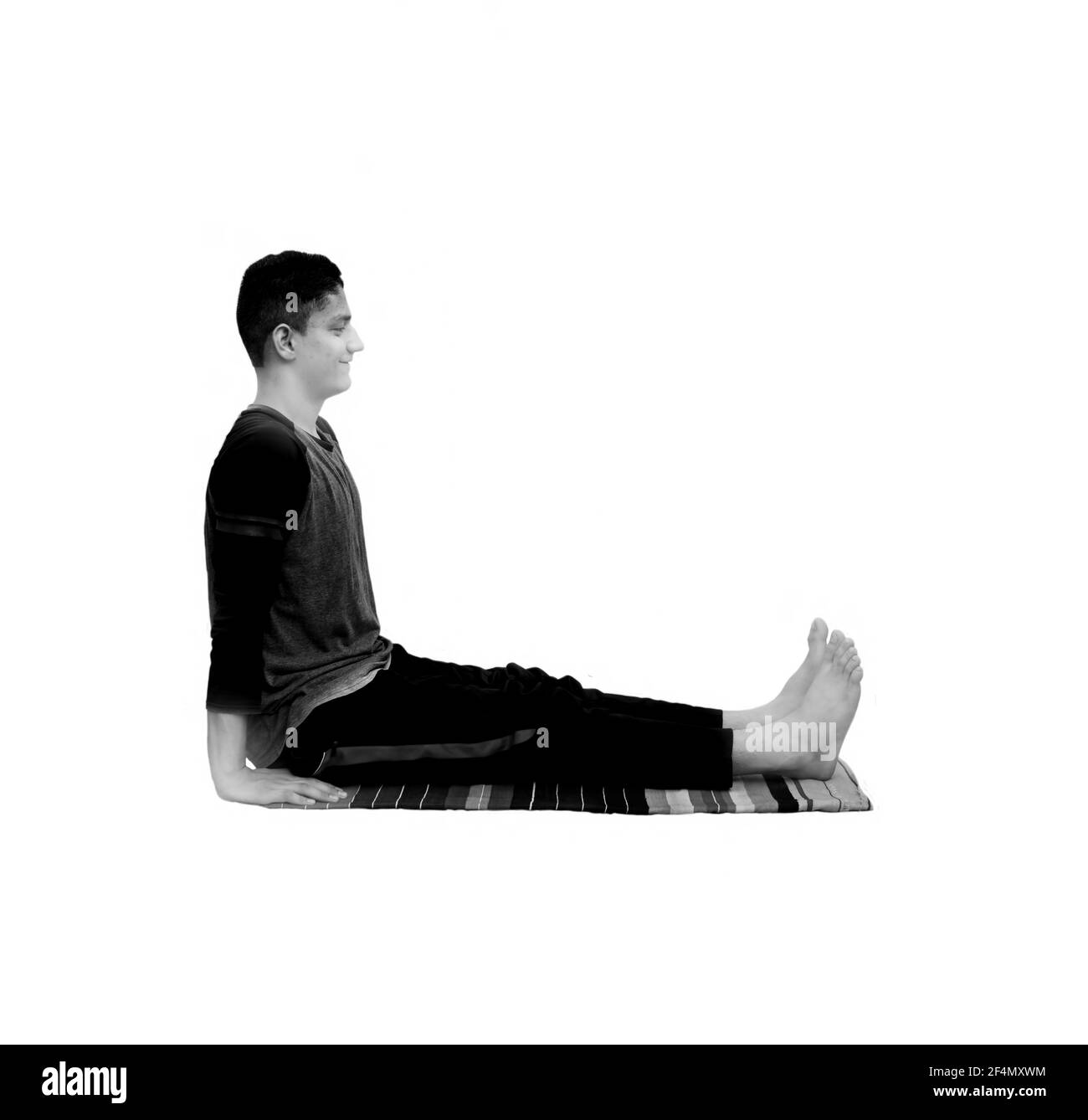 Shot of a teenage boy doing Staff Pose or Dandasana isolated on white ...