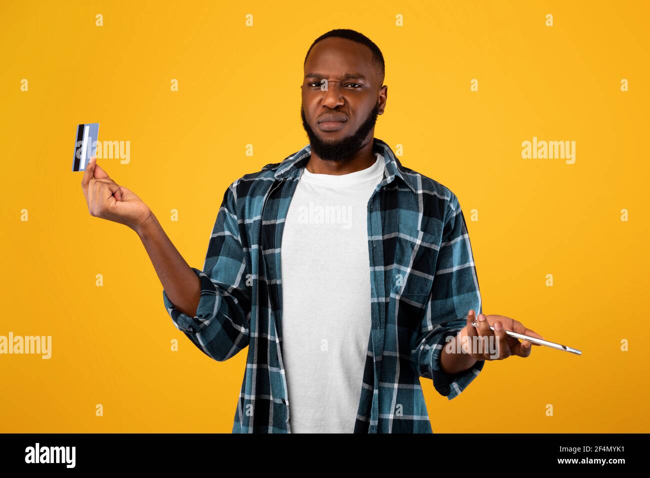 Discontented Black Man Holding Phone And Credit Card, Yellow Background ...