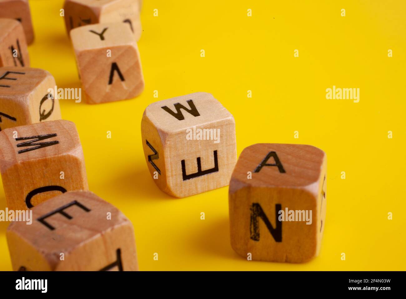 Wooden letter dices alphabet on yellow background Stock Photo - Alamy