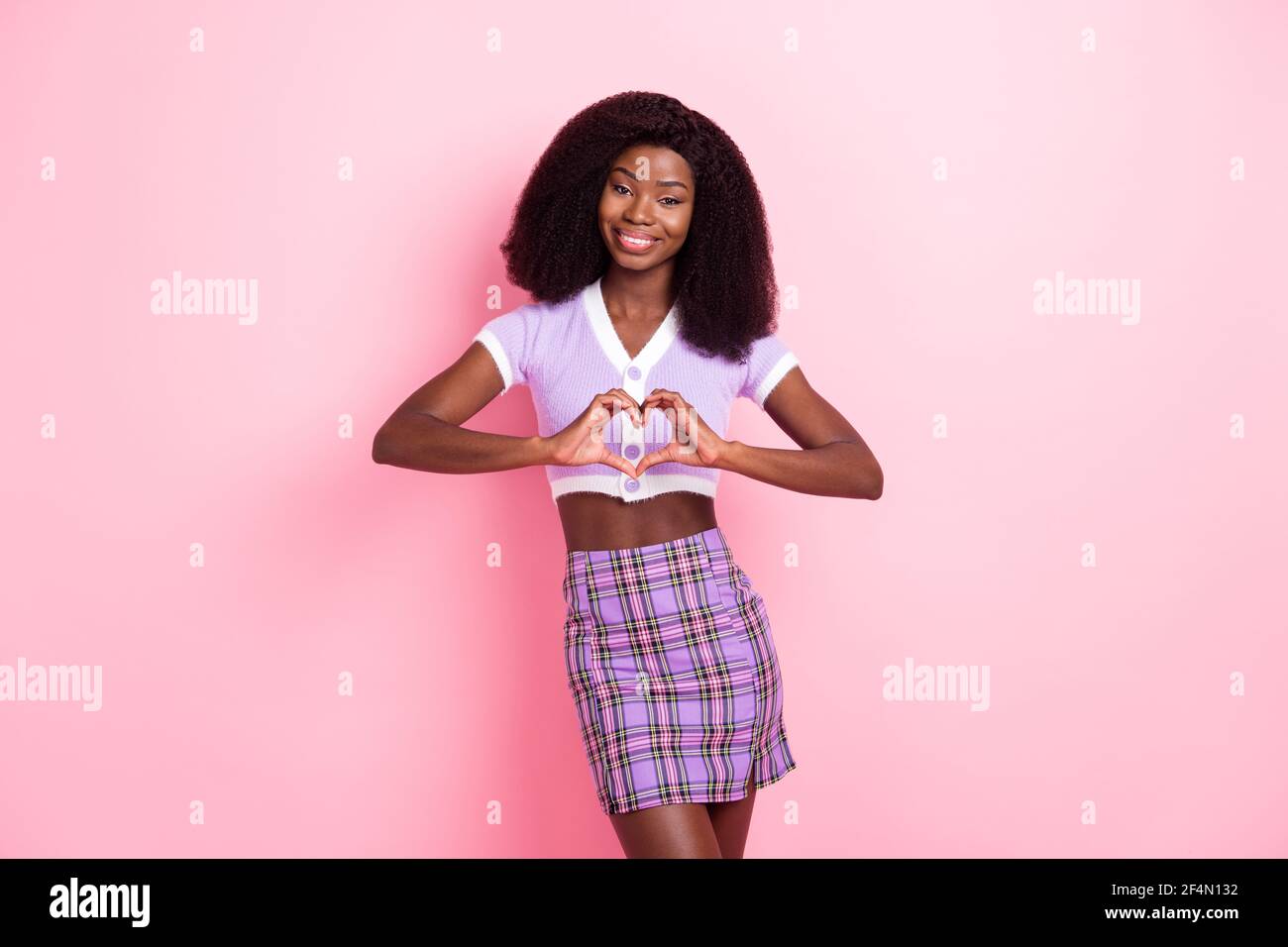 Portrait of attractive cheerful wavy-haired girl showing heart shape ...