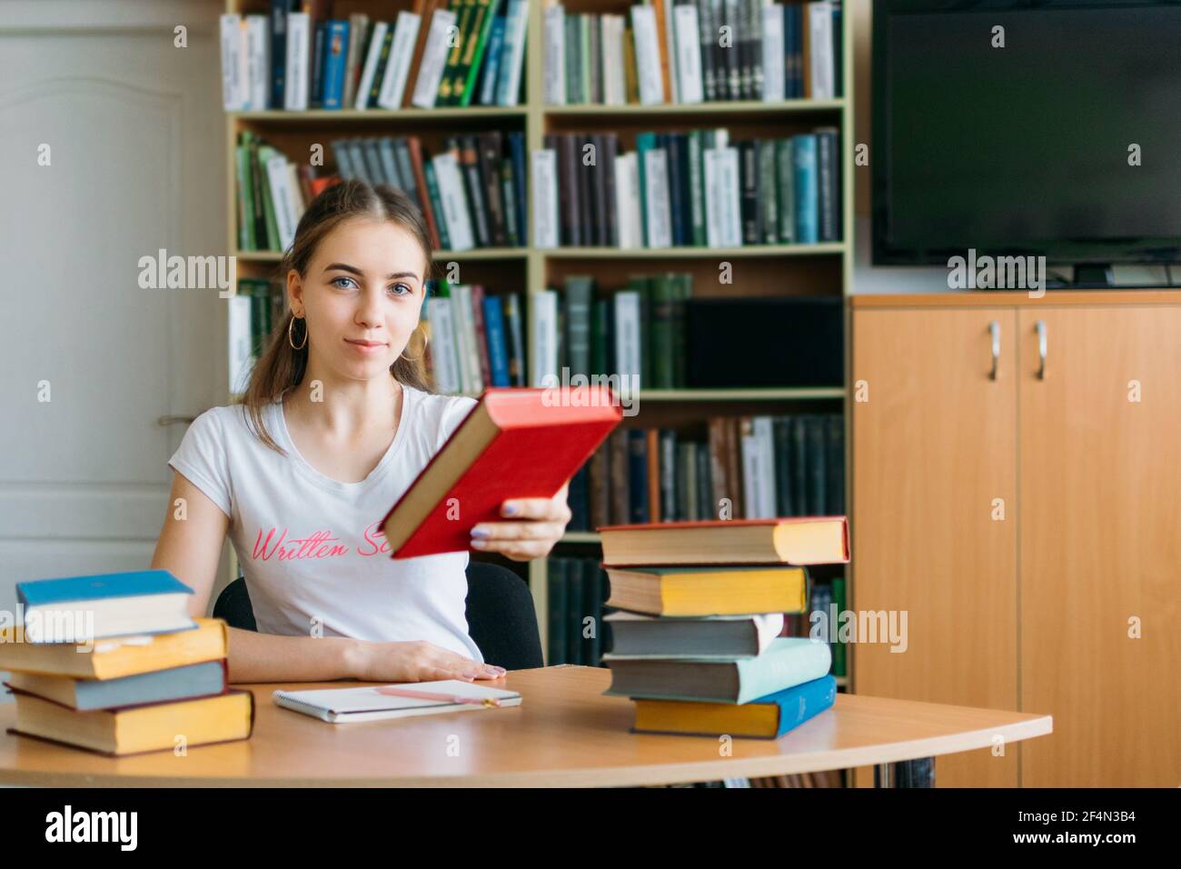 Back to school library concept. Student girl holding book on her head ...