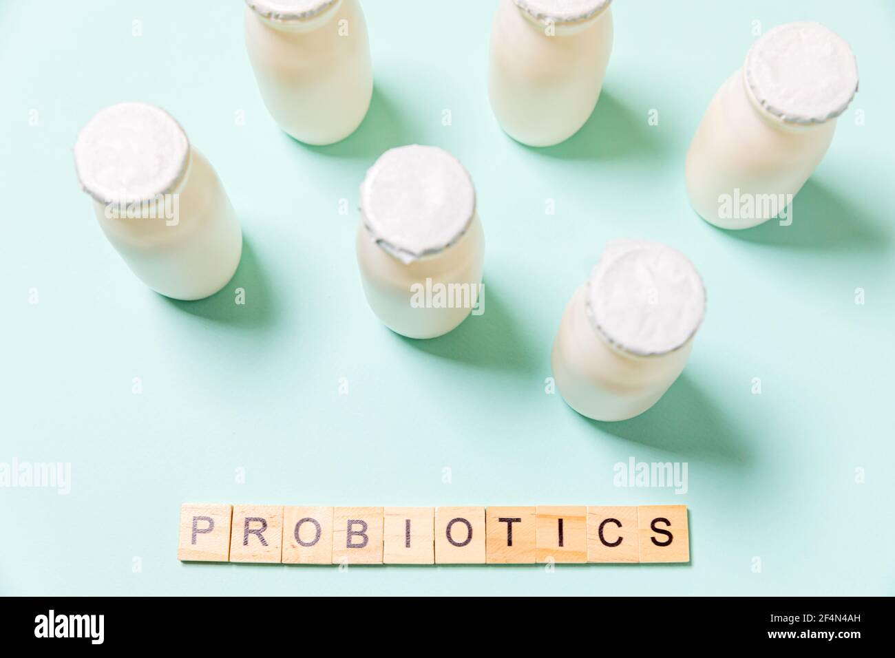 Small bottles with probiotics and prebiotics dairy drink on blue ...