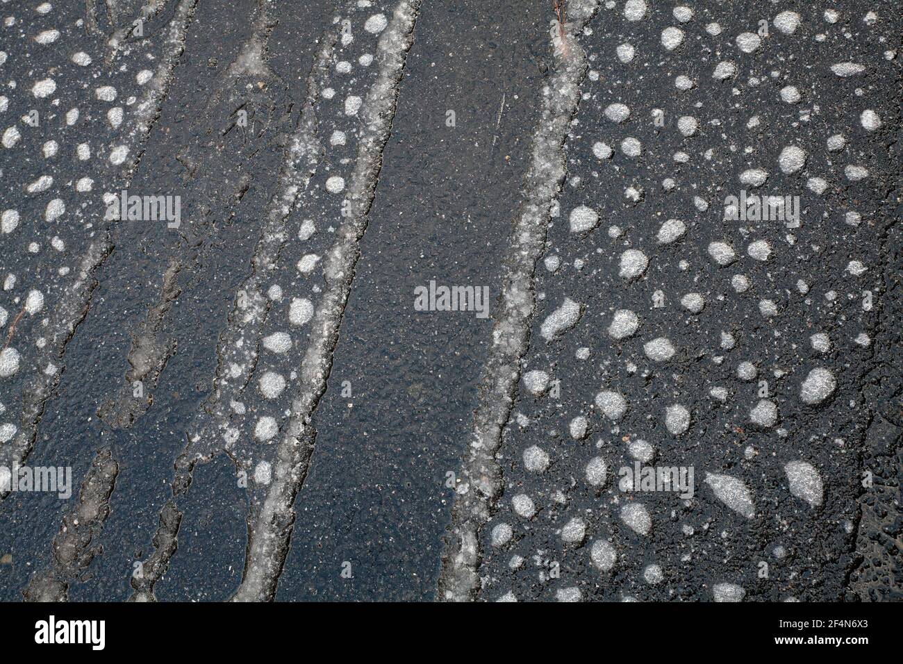 Strange dots on a sheet of ice on asphalt Stock Photo - Alamy