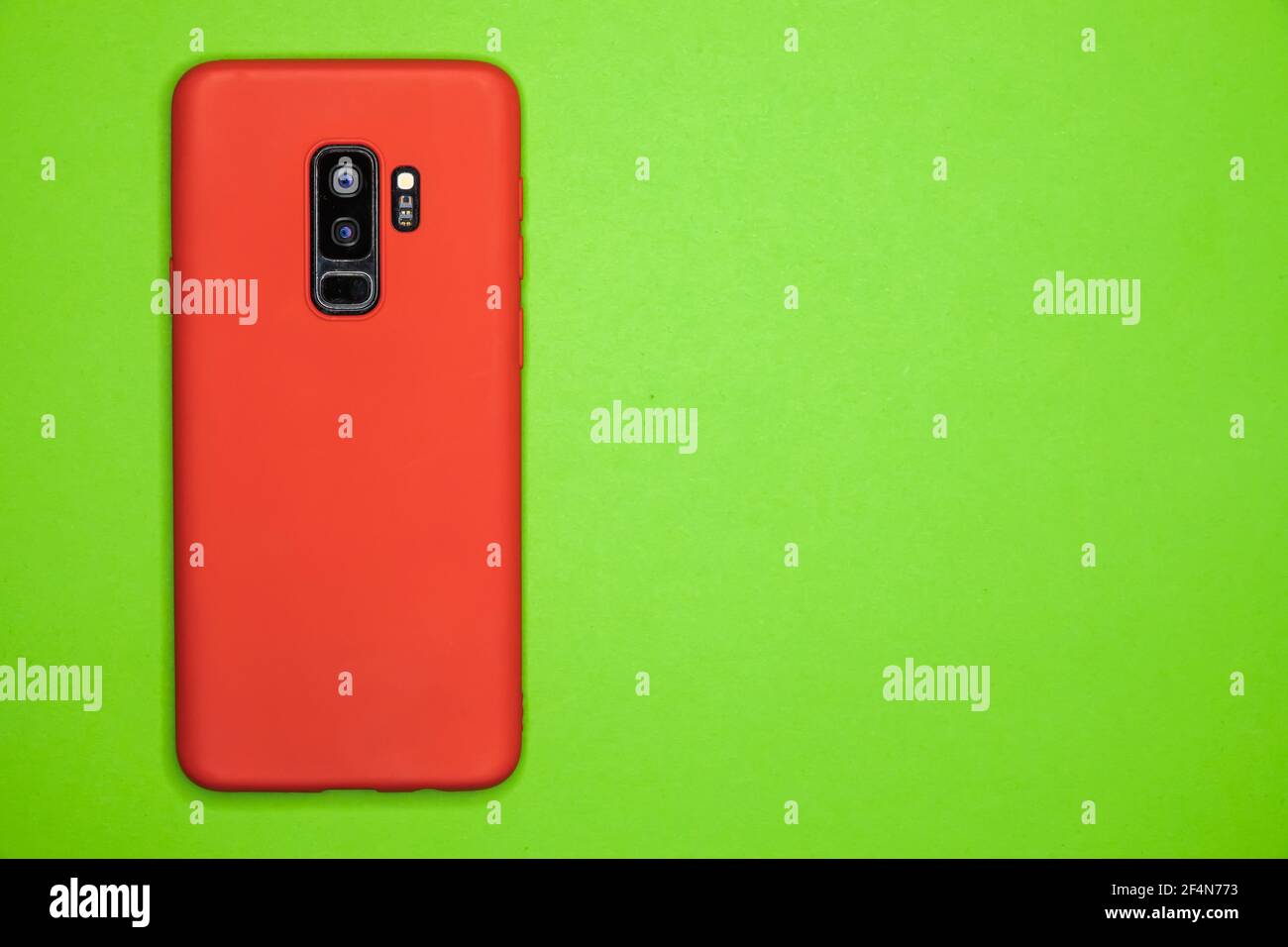 Top view of red mobile phone cas isolated on green background with copy ...