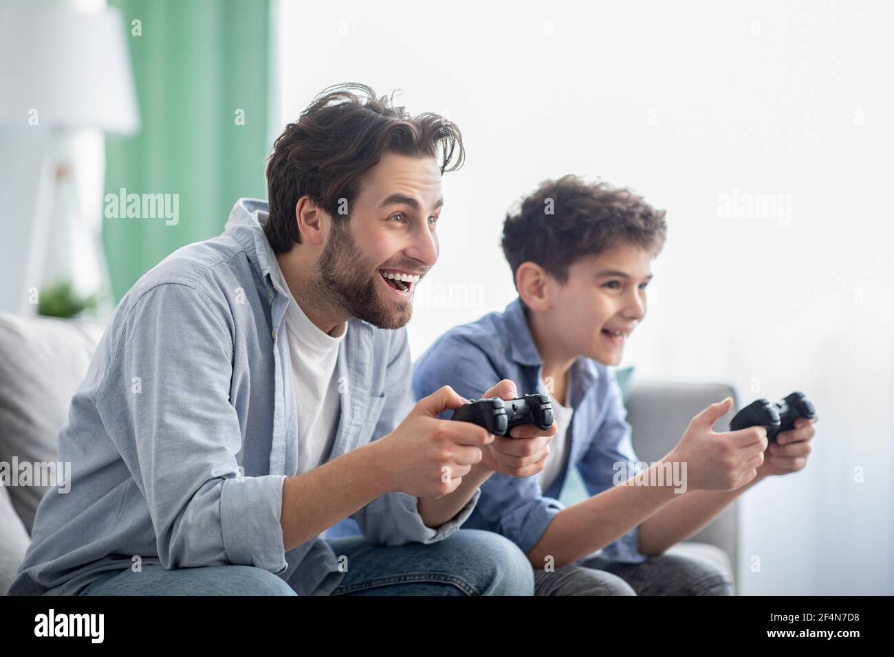 Stay at home with fun. Happy dad and son competing with each other in ...