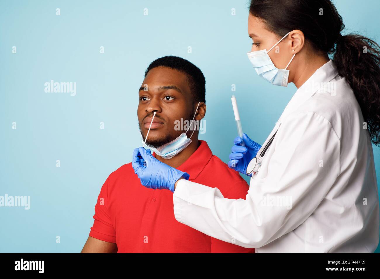 Doctor Making Covid-19 PCR Test For Male Patient, Blue Background Stock ...
