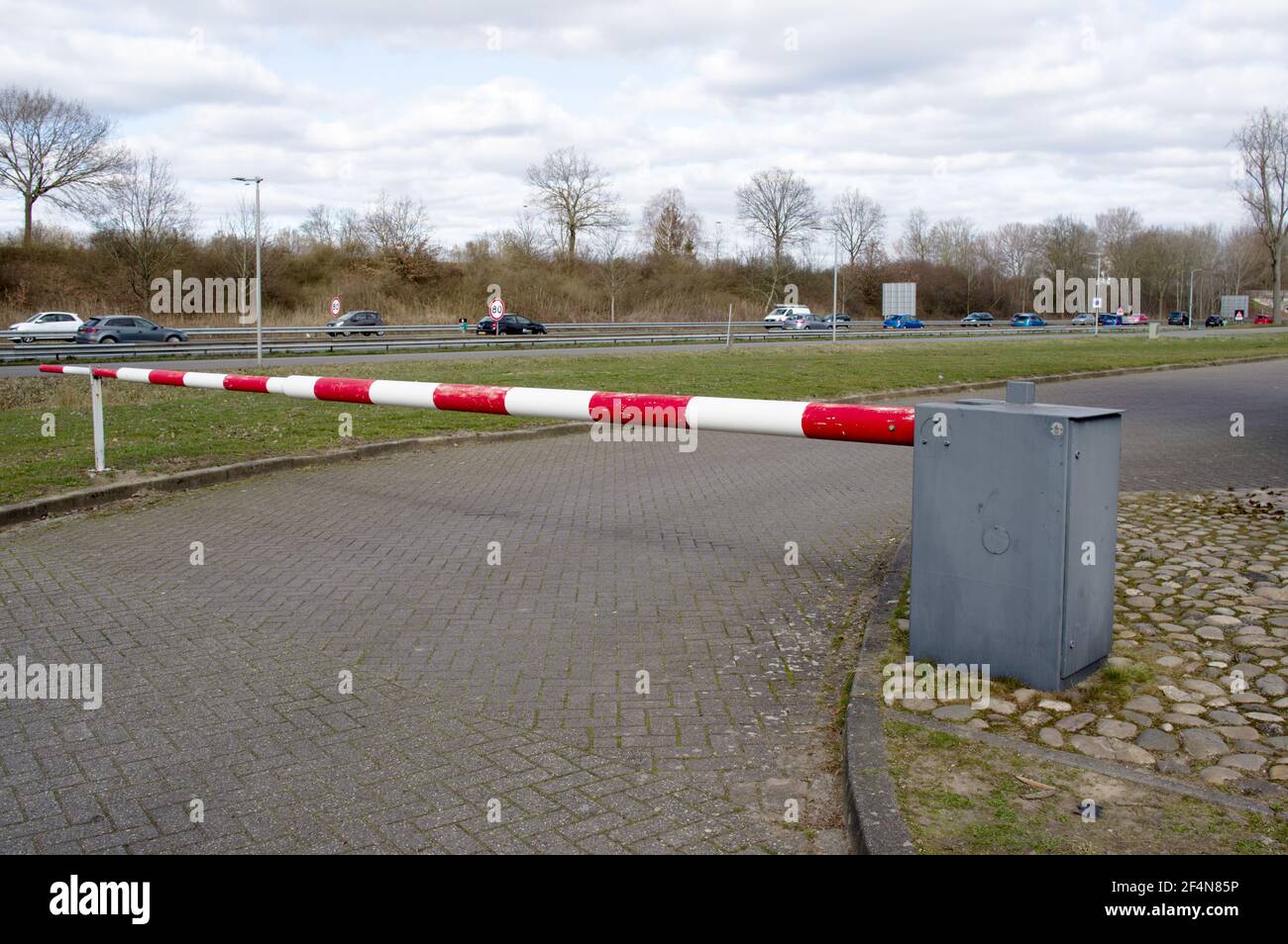 Closeup of a closed barrier gate with traffic in the background Stock ...
