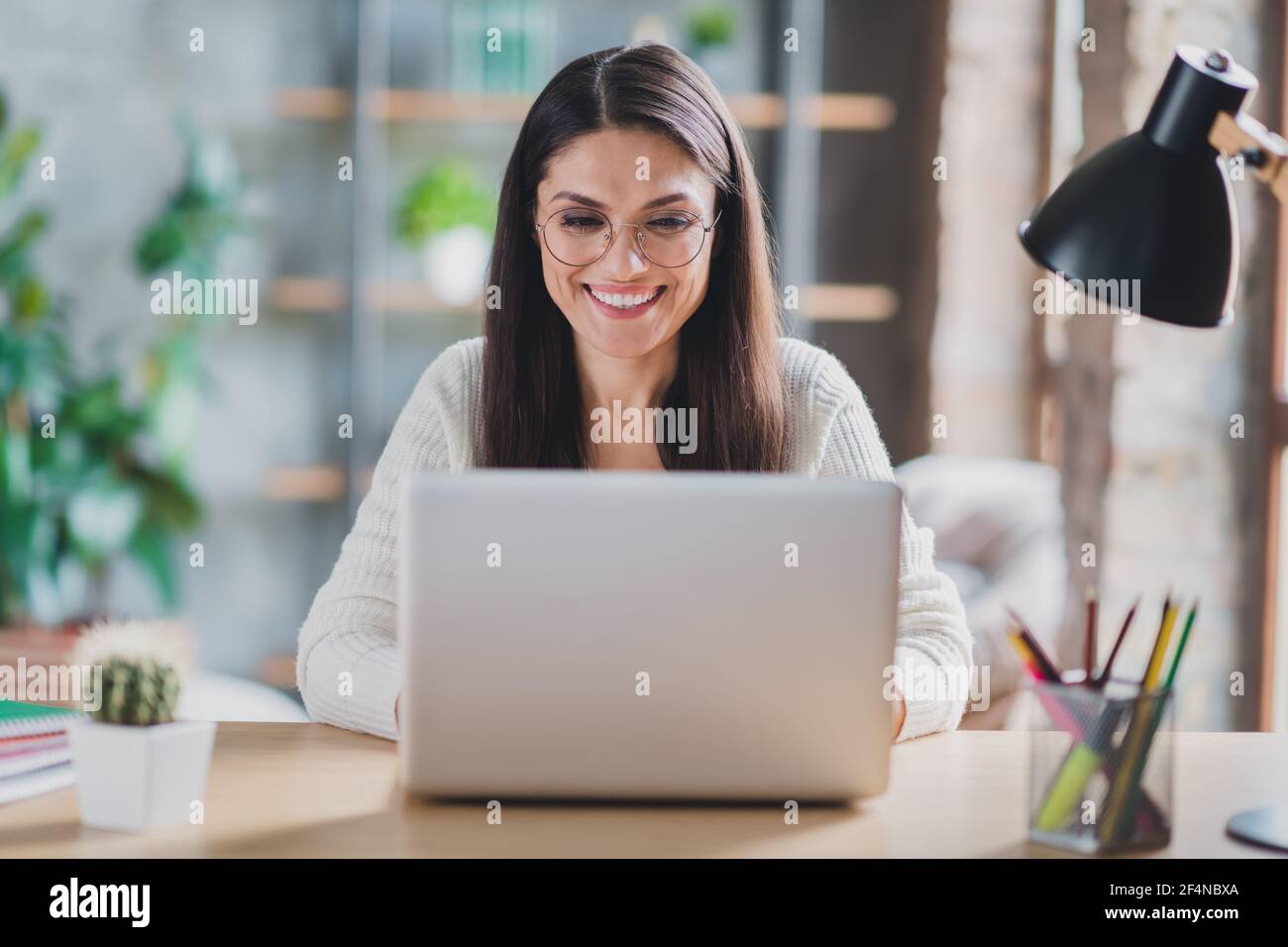 Photo of worker lady sit desk work computer look screen beaming smile ...