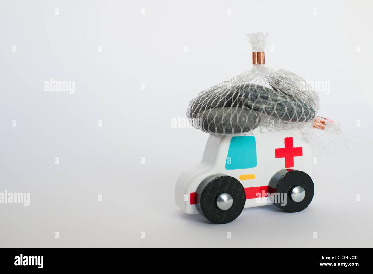 Close up of an ambulance toy carrying a heavy load (stones). Conceptual ...