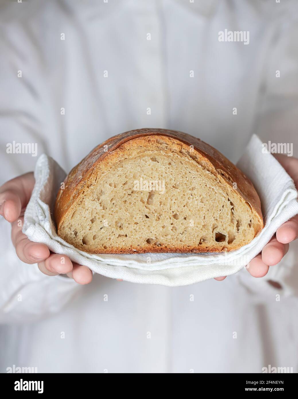 Female baker holds home made artisan organic bread fresh from the oven ...
