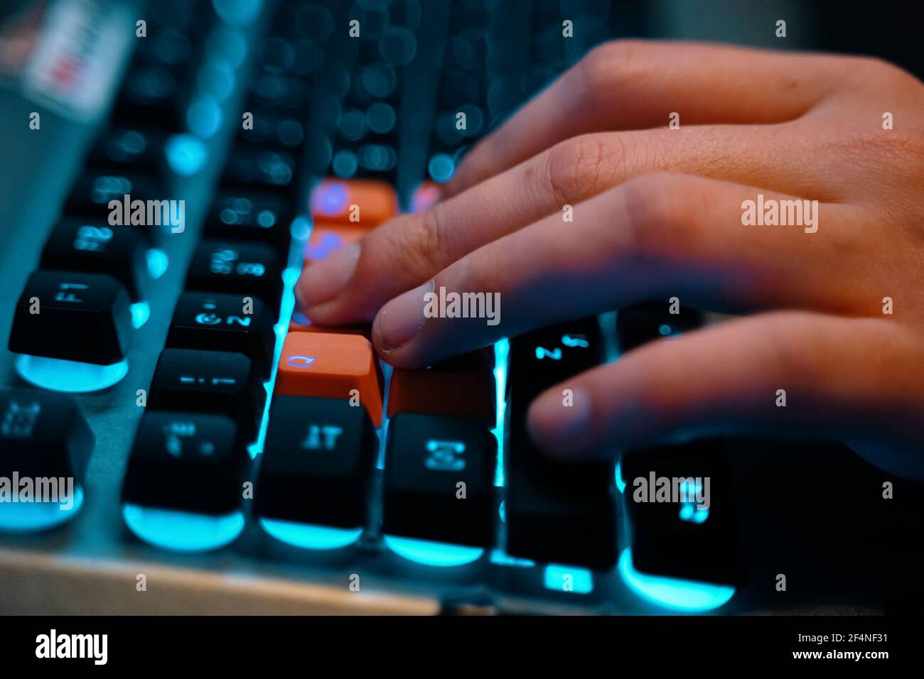 Multifunction keyboard with set of red keys and backlit. Employee uses ...