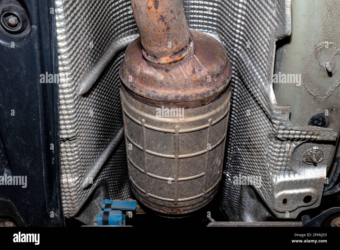 A diesel particulate filter in the exhaust system in a car on a lift in ...