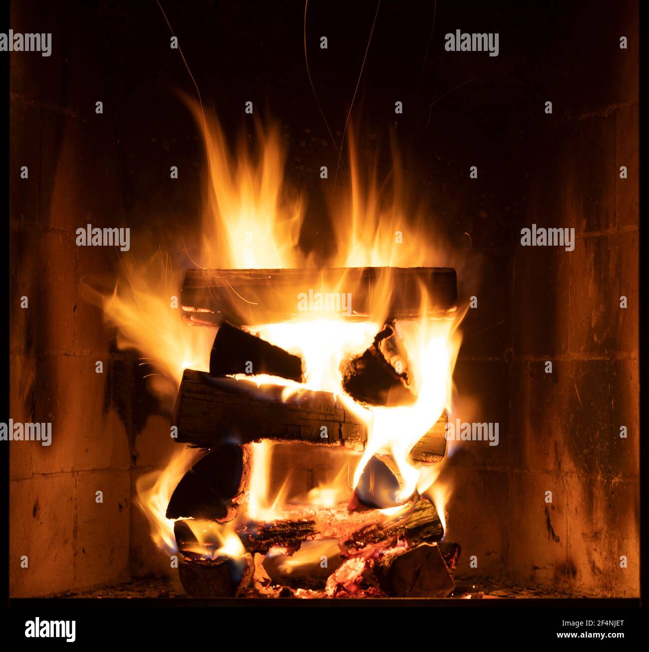 Brick fireplace closeup with wood and coal burning and sparks Stock ...