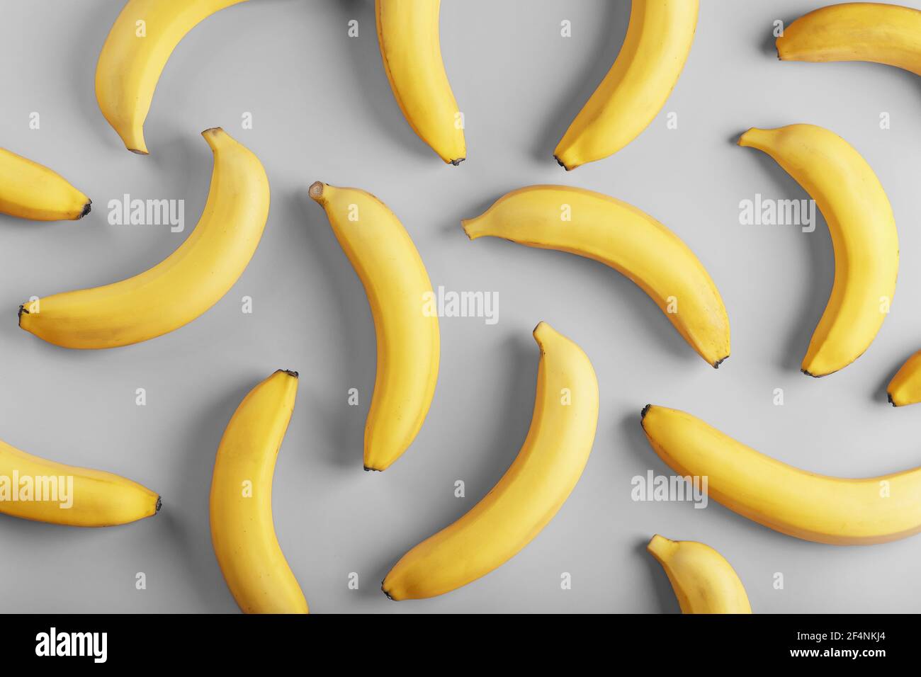 Bright pattern of yellow bananas on a gray background. View from above ...