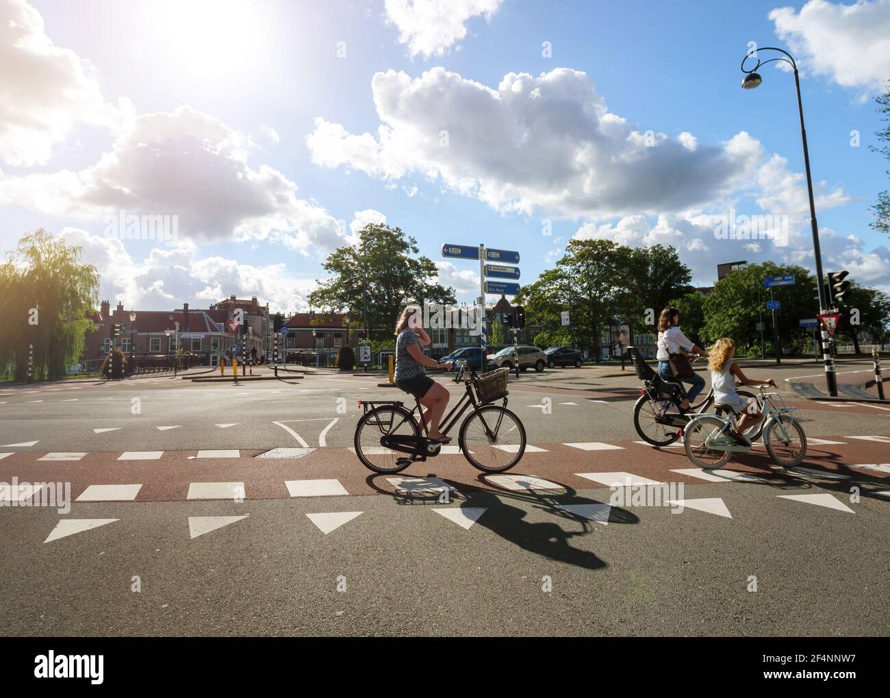 Side view of main street with women and young girl on bicycle crossing ...