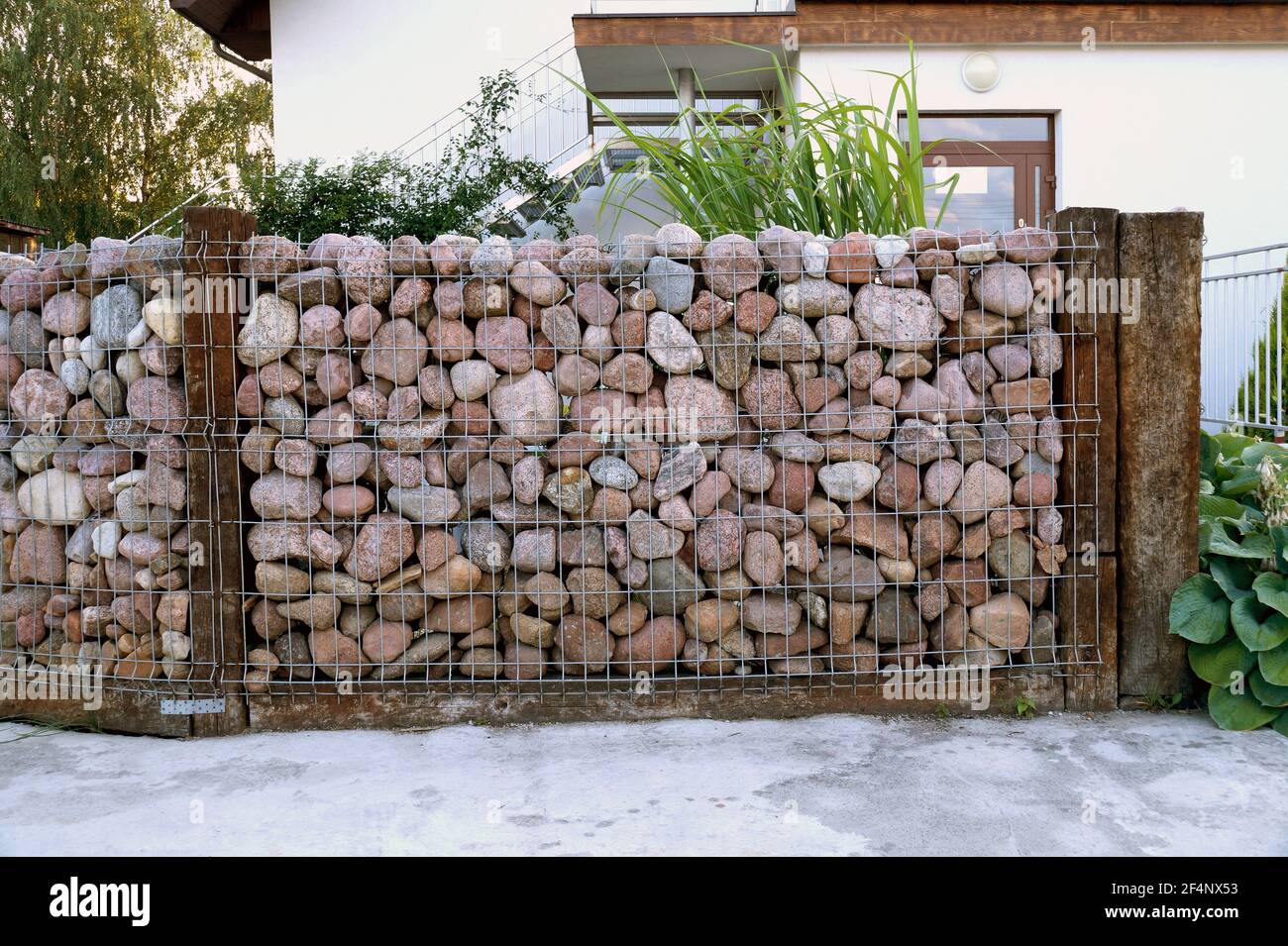 A specific form of a gabion made of pebble stones. Self-made fence made ...