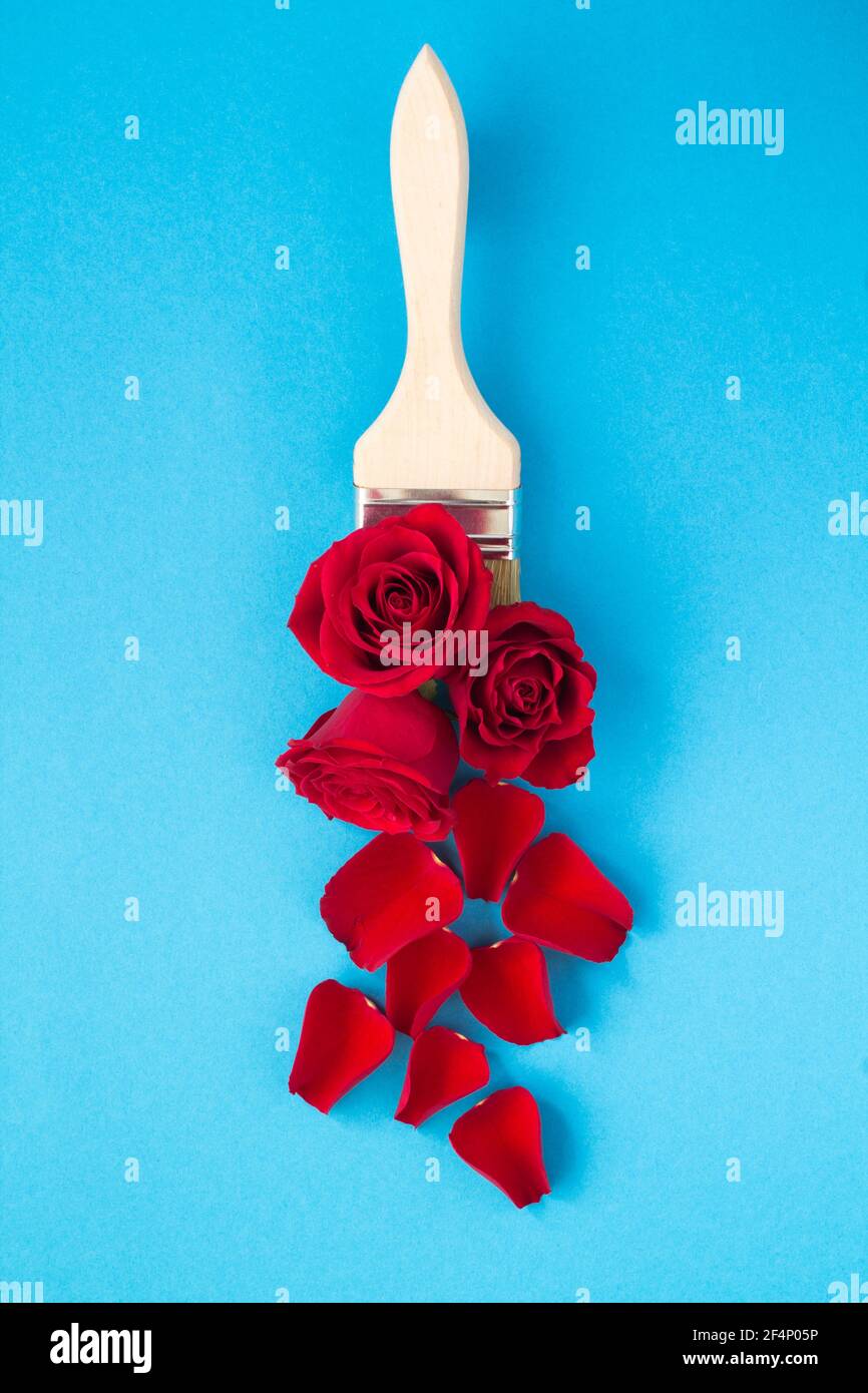 Top view of paintbrush with red roses on the blue background. Location ...