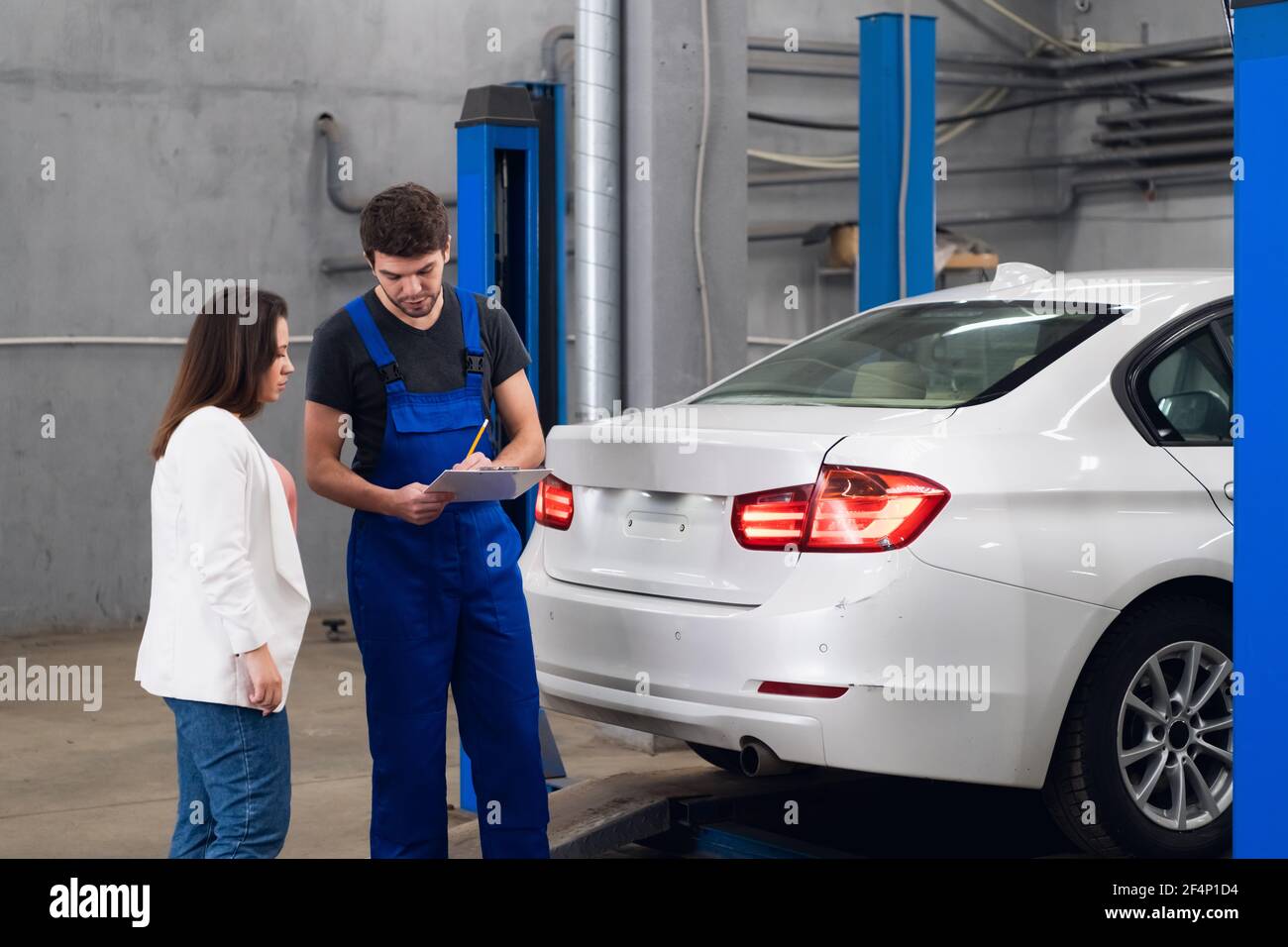 Client talking to car mechanic about car repair Stock Photo - Alamy