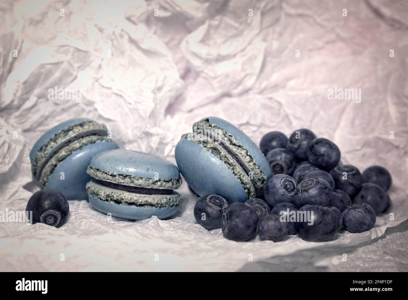Delicious blueberry macaroons and fresh blueberries on white background ...
