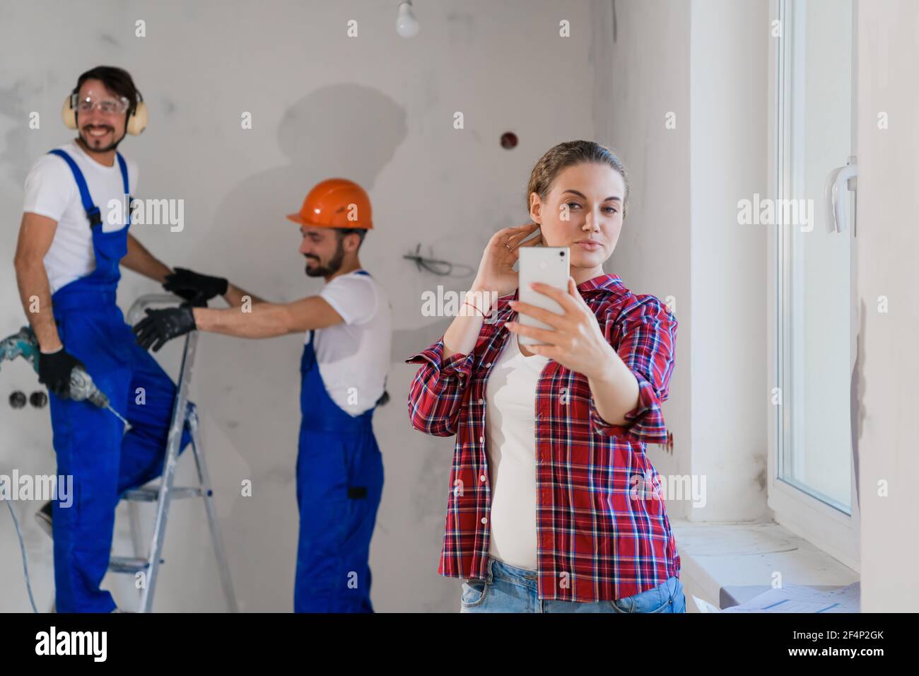 Woman takes a selfie on the background of workers at work Stock Photo ...