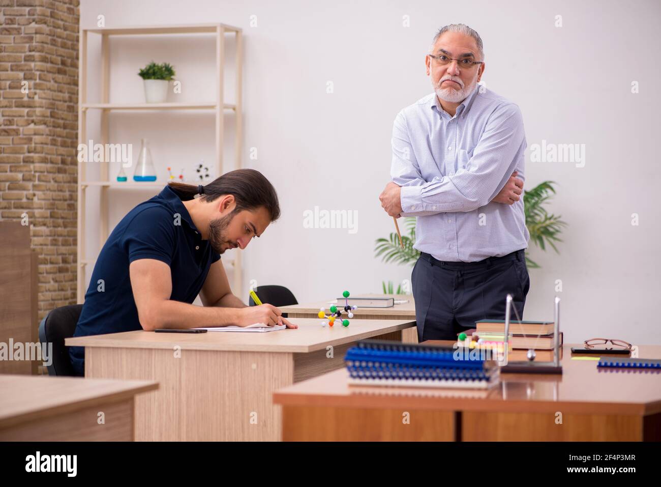 Old male teacher and young student in the classroom Stock Photo - Alamy