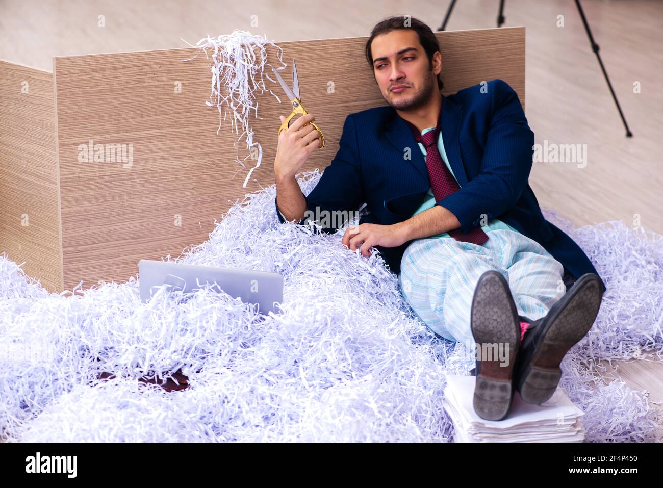 Young businessman employee and a lot of cut papers in the office Stock ...