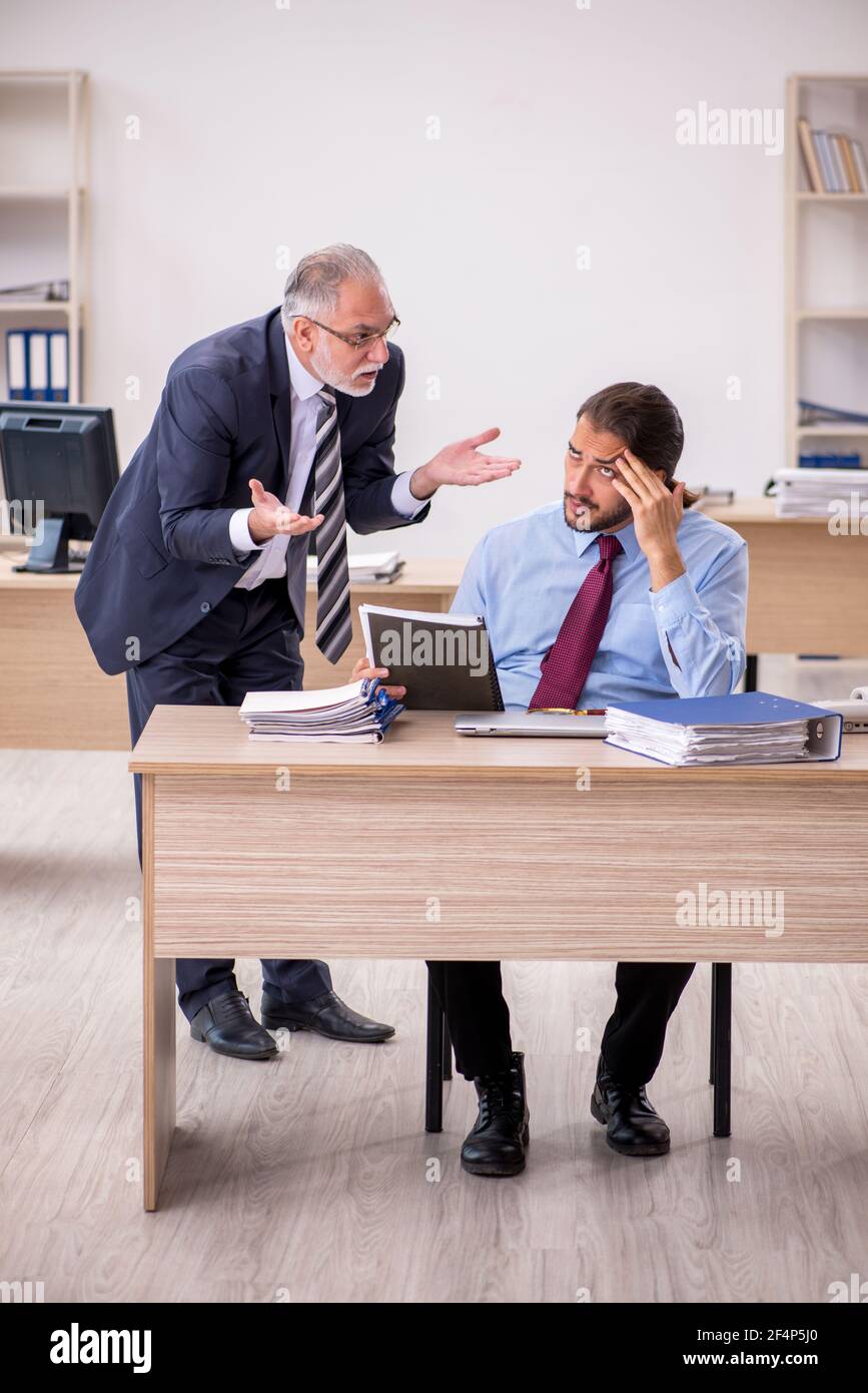 Old boss and young employee working in the office Stock Photo - Alamy