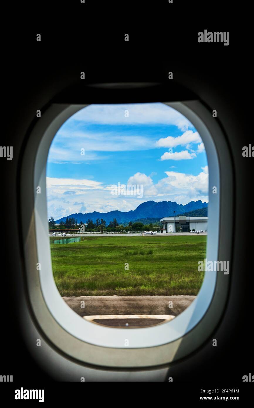 View from the window of an airplane on the runway of a tropical island ...