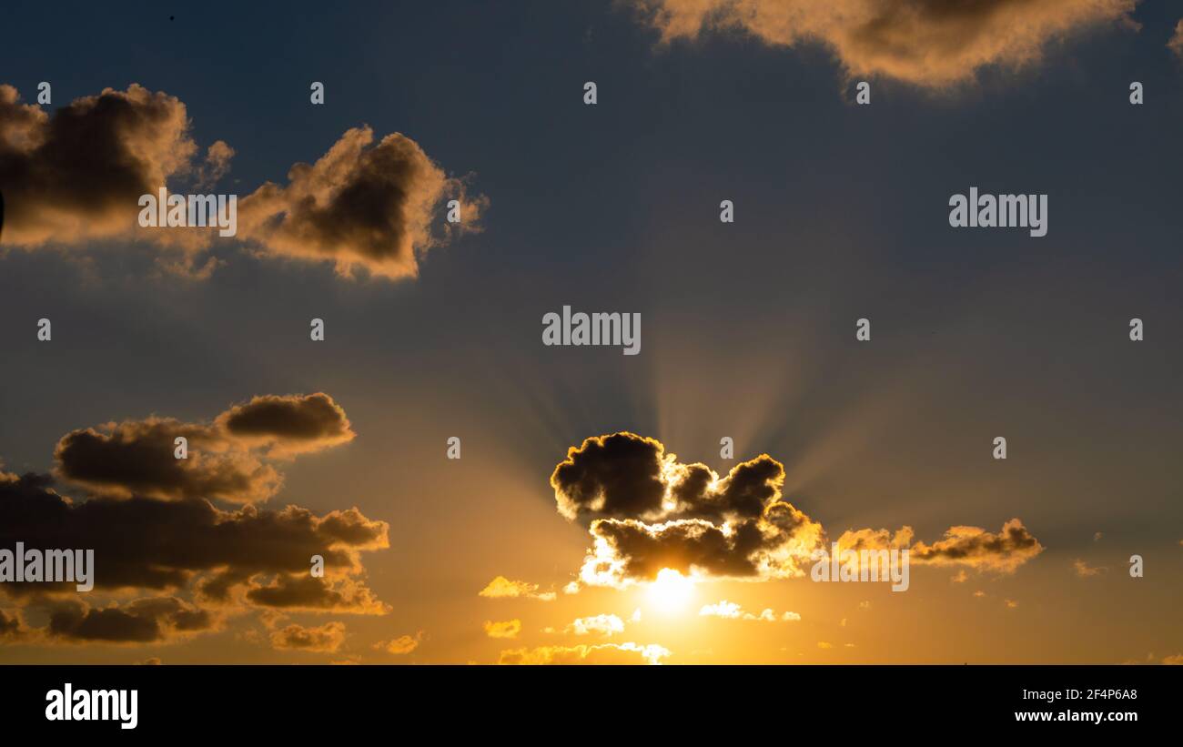 Silhouette of clouds and sunlight beams at sunset. Sunset background ...