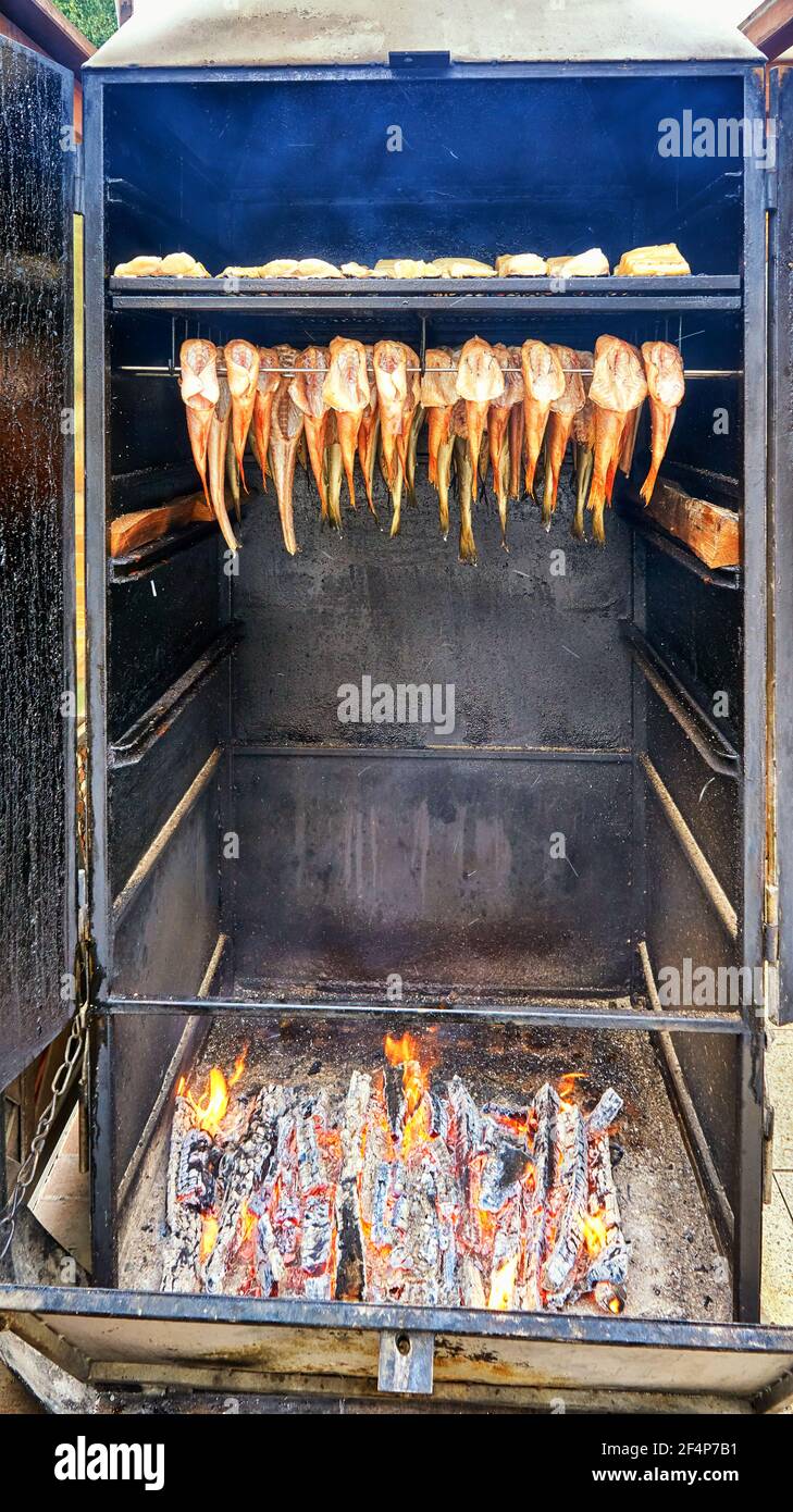 Rustic smoker with fire and fresh fish Stock Photo - Alamy