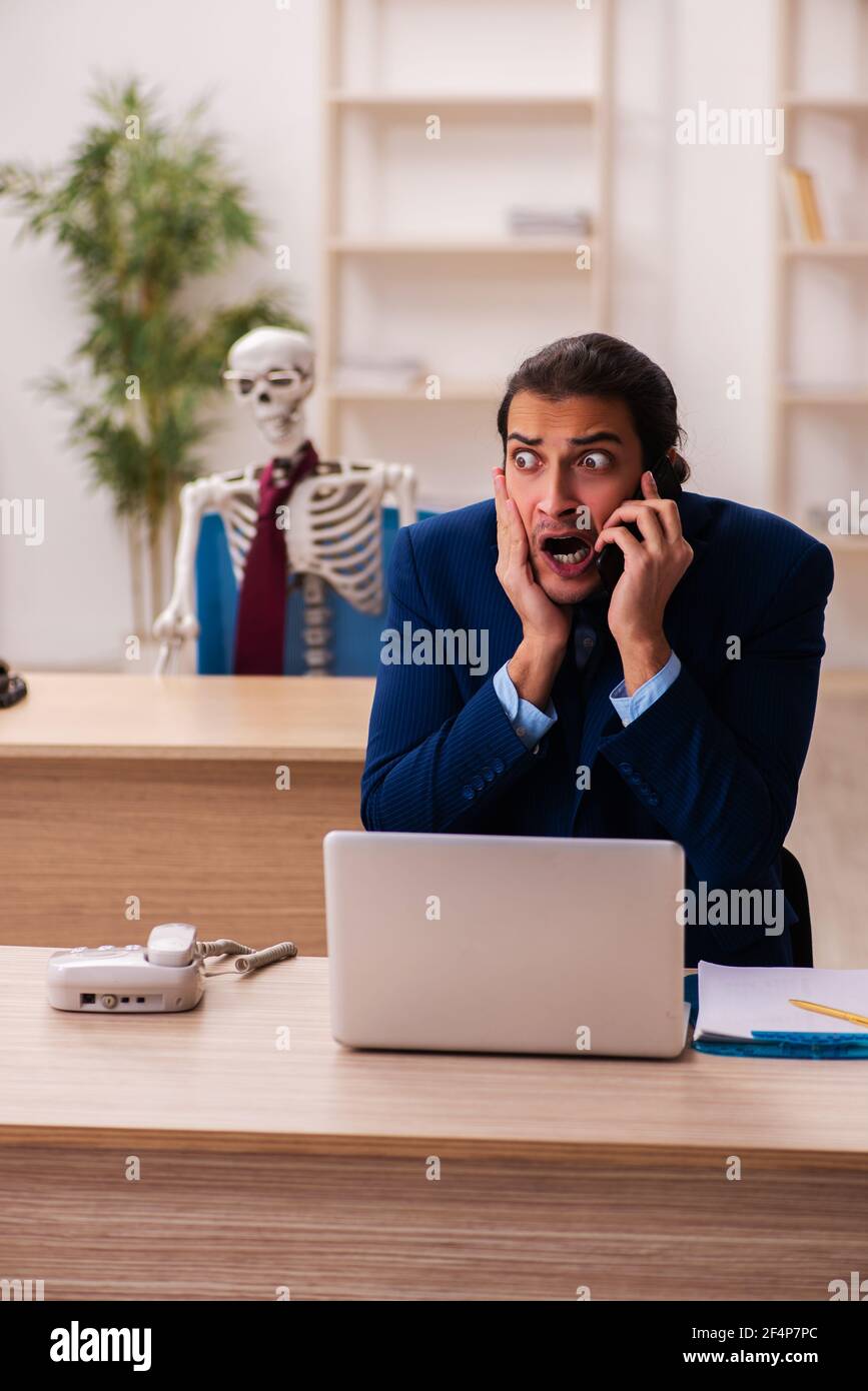 Dead employee working in the office in funny concept Stock Photo - Alamy