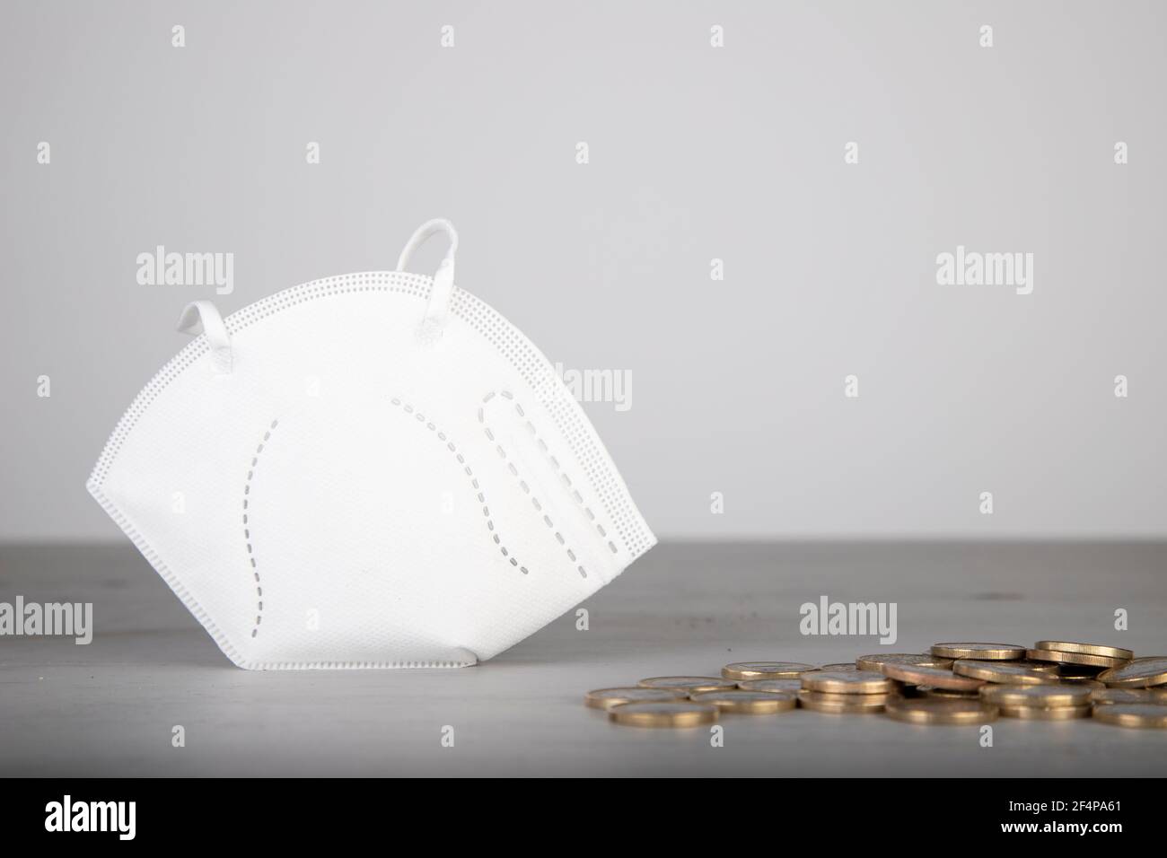 ffp2 mask with many one EURO coins as symbol for cost for corona ...