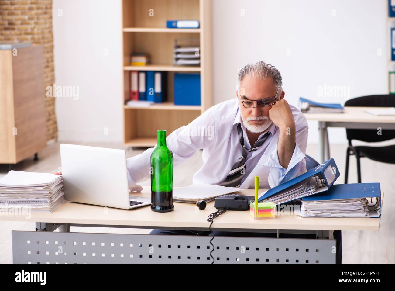 Old businessman drinking alcohol in the office Stock Photo - Alamy