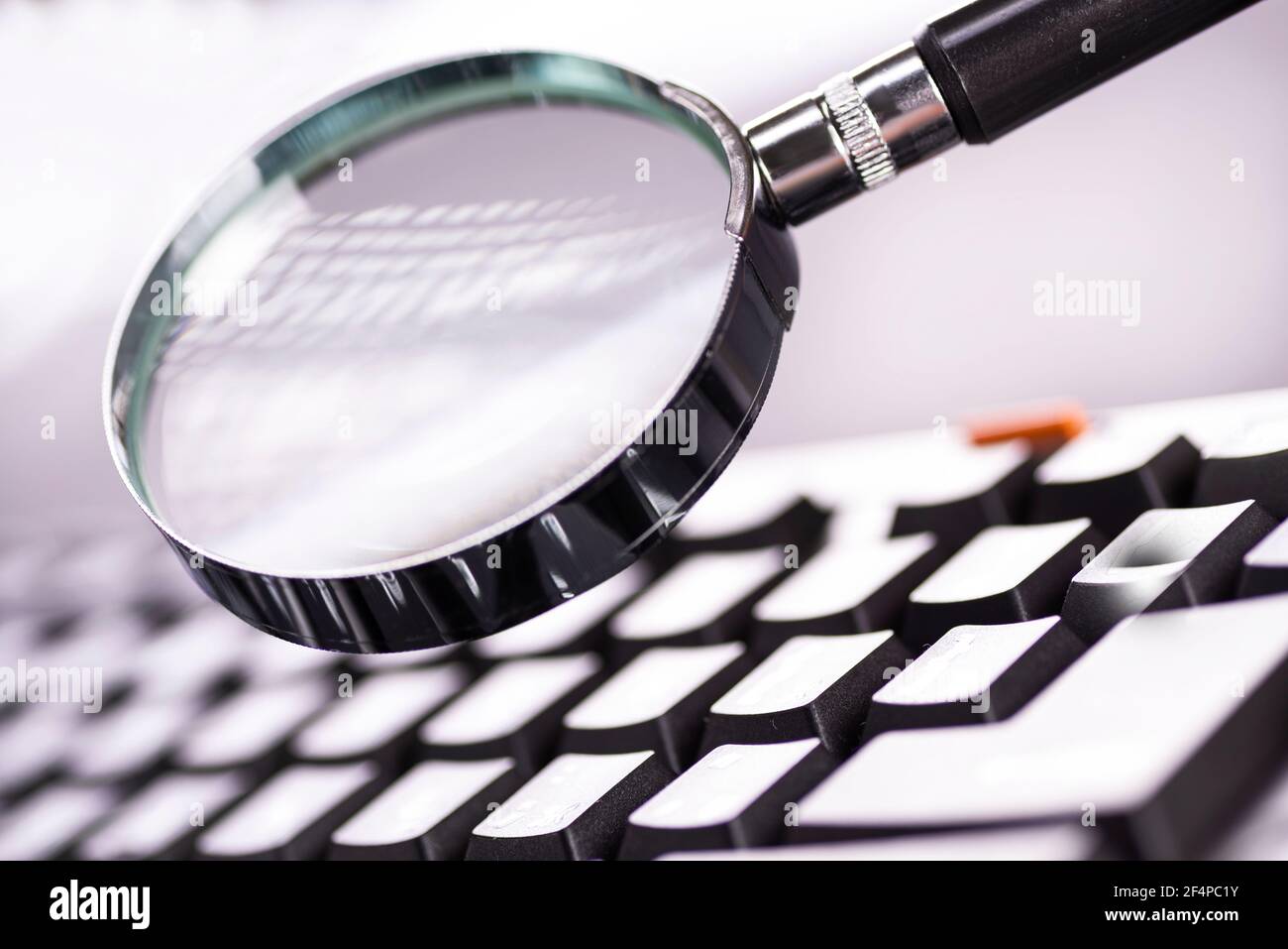Magnifying glass on the keys of a black computer keyboard Stock Photo ...