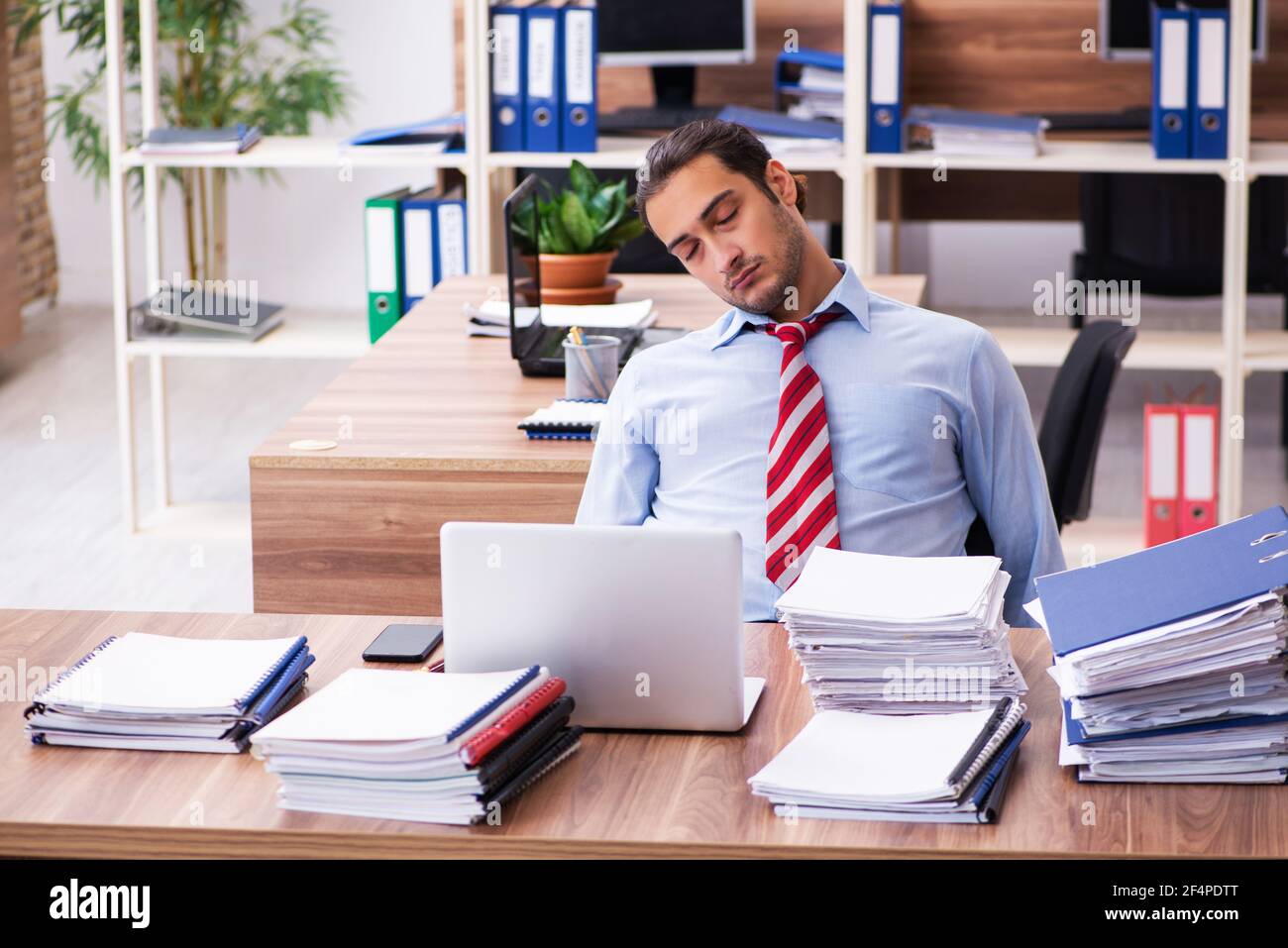 Young employee unhappy with excessive work Stock Photo - Alamy