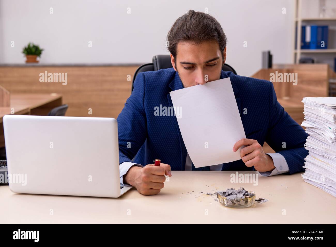 Young male employee reading contract at workplace Stock Photo - Alamy