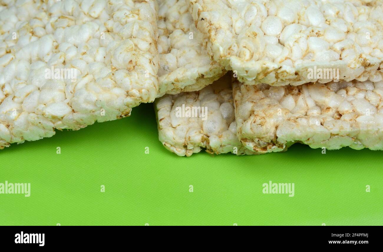 Puffed rice cakes on green background. Stack of puffed whole grain ...