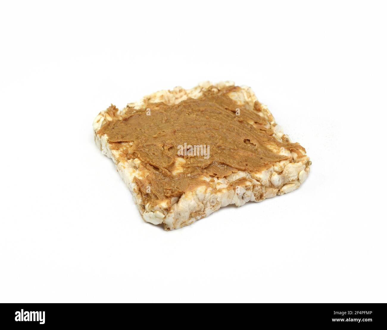 Puffed rice cakes smeared with peanut butter isolated on white. Stack ...